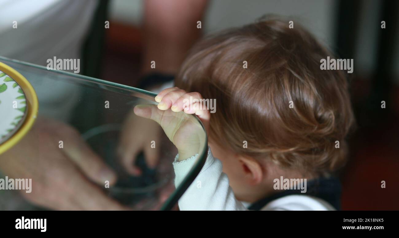 Baby holding into tablet with hand grabbing berries. Infant toddler ...