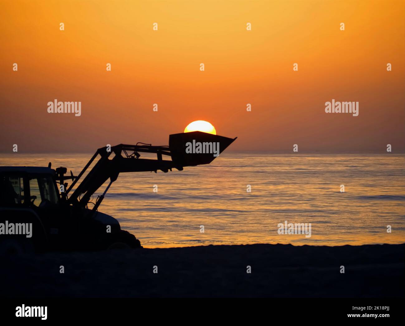 Tractor at sunset at a beach Stock Photo - Alamy