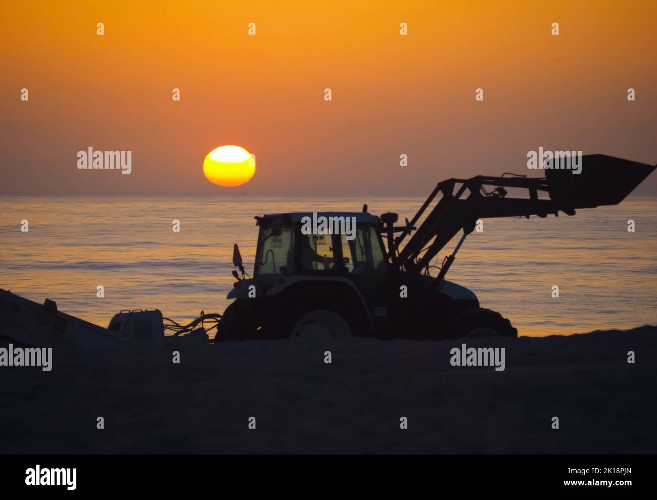 Tractor at sunrise at a beach Stock Photo - Alamy