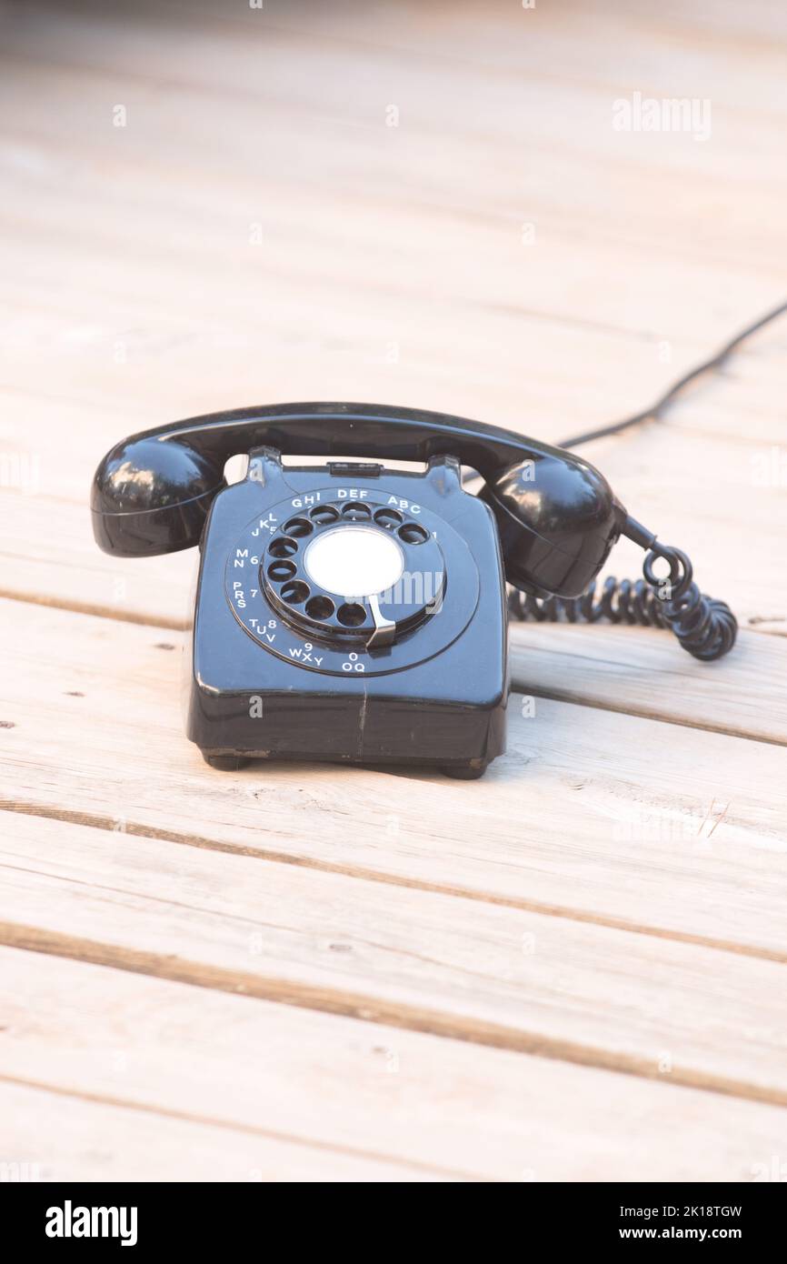 Old fashioned rotary dial analogue telephone on wooden floorboards ...