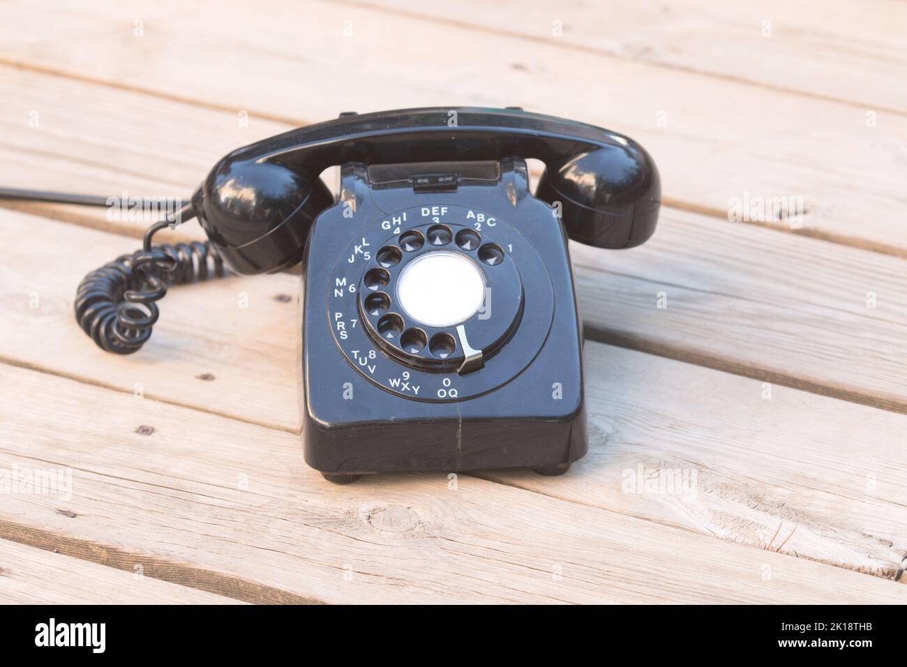 Old fashioned rotary dial analogue telephone on wooden floorboards ...
