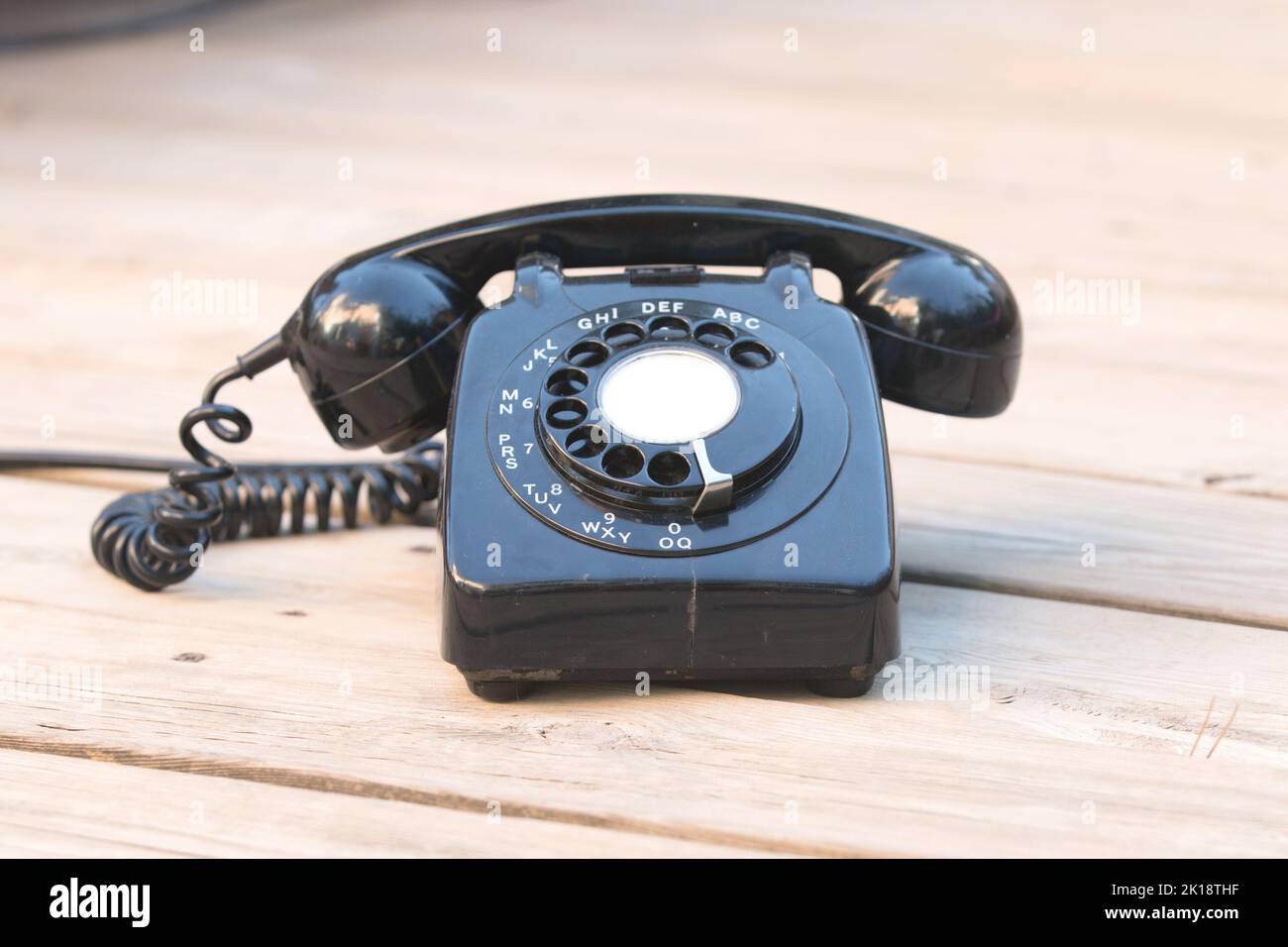Old fashioned rotary dial analogue telephone on wooden floorboards ...