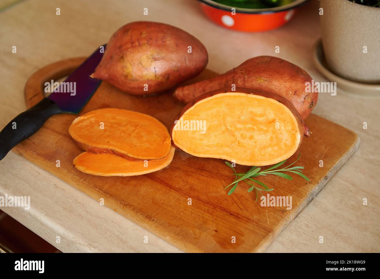 Top view of whole and sliced tuber of organic raw orange color sweet ...