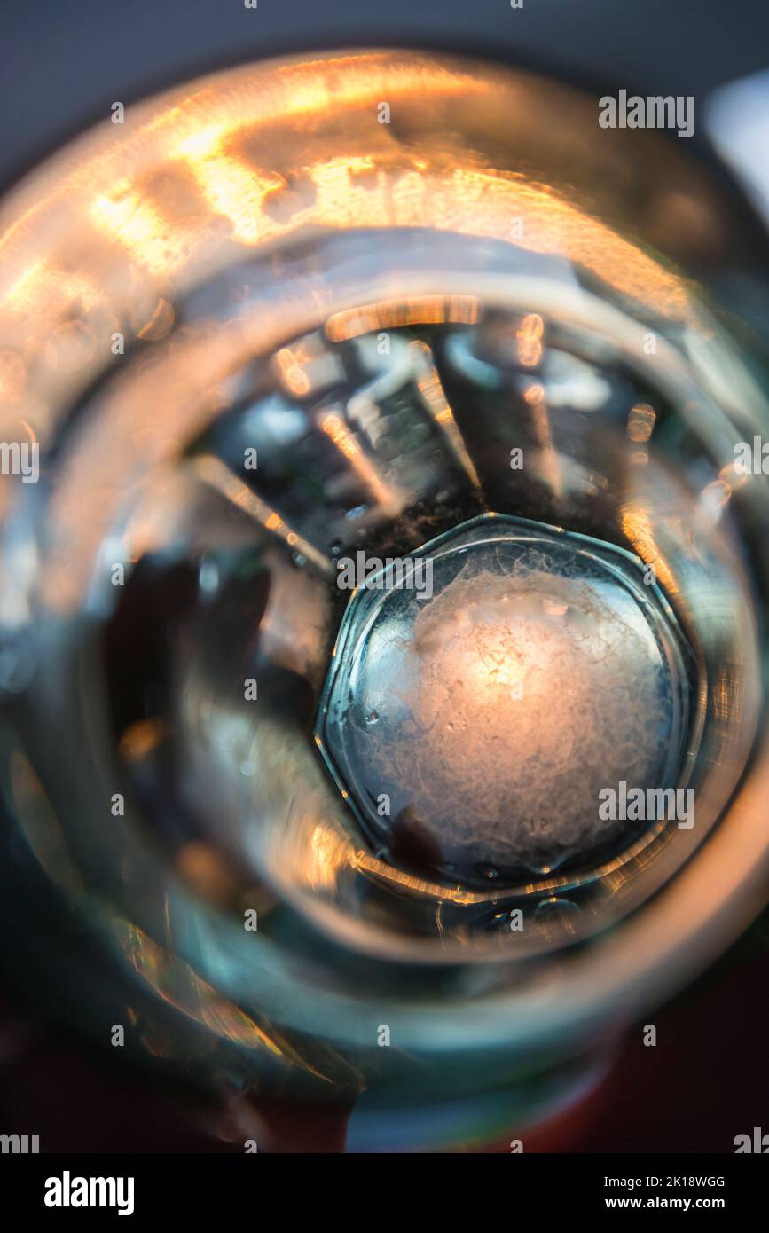 Looking at the bottom of an empty glass with sunlight reflections Stock ...