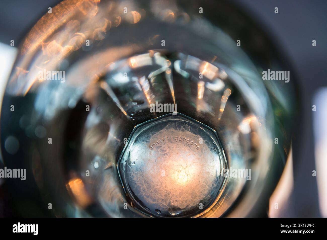 Looking at the bottom of an empty glass with sunlight reflections Stock ...