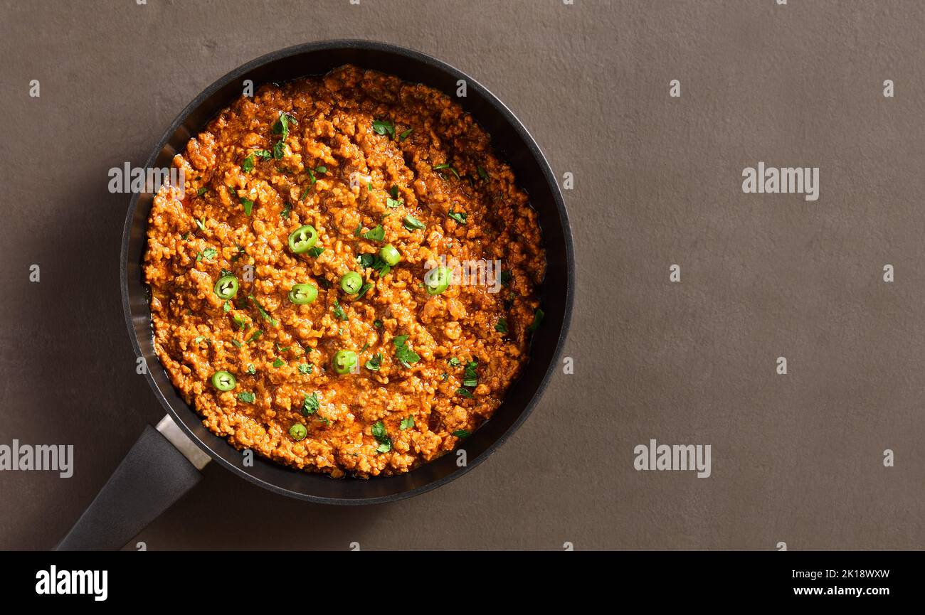 Keema curry in cooking pan over dark background with copy space. Indian ...
