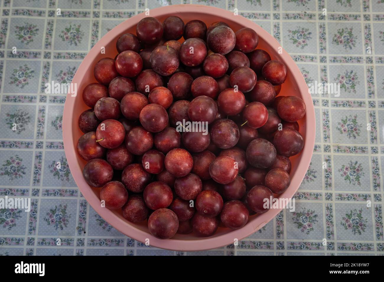 Fresh red plums on patterned table in a pile Stock Photo - Alamy