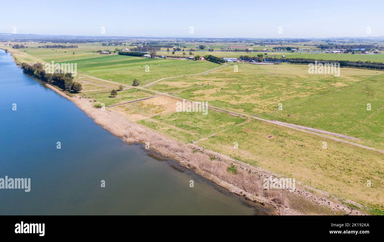 An aerial view of the farm surrounded by a beautiful river and lush ...