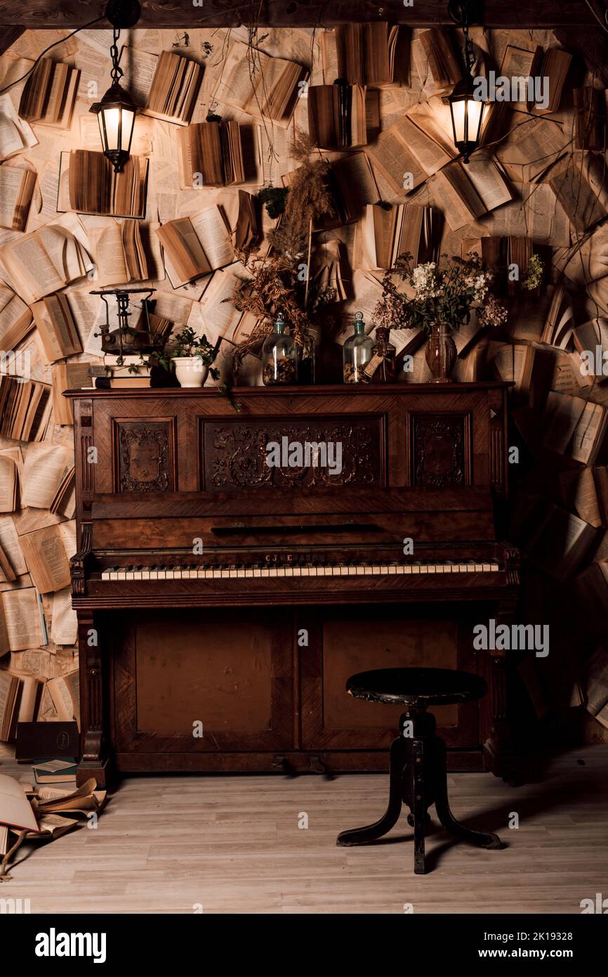 An old piano in a dark room. Lots of books on the walls Stock Photo - Alamy