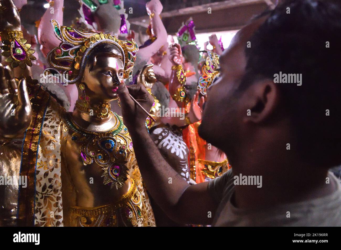 An artist is finishing the Vishwakarma clay idol ahead of the annual ...