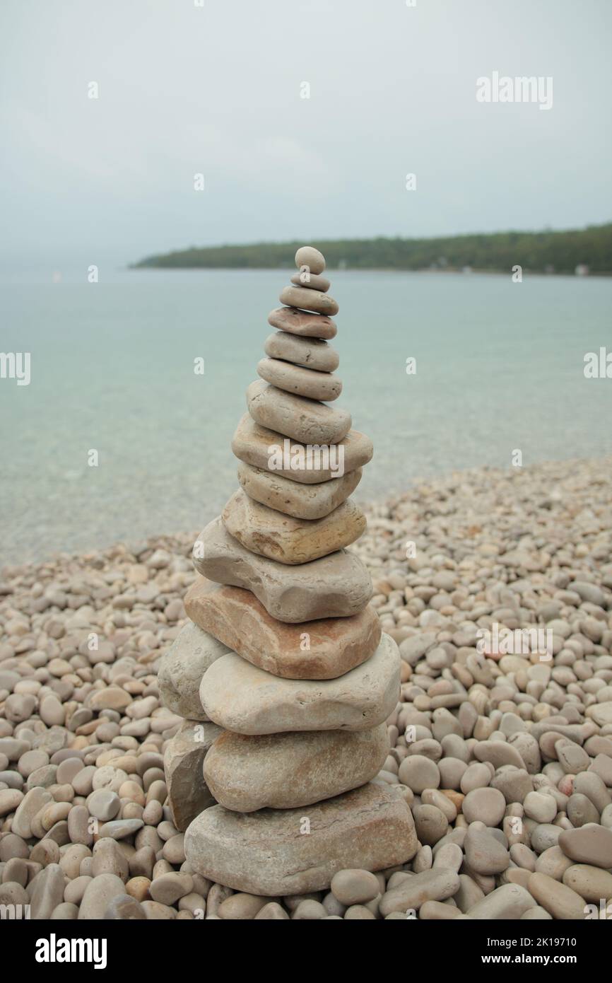 Cairn rocks on a pebble beach near water Stock Photo - Alamy