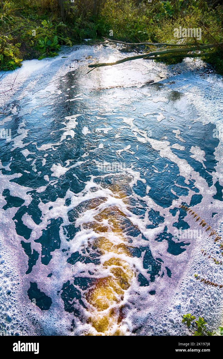 Brown swamp water full of organic substances flows down the pipe and ...