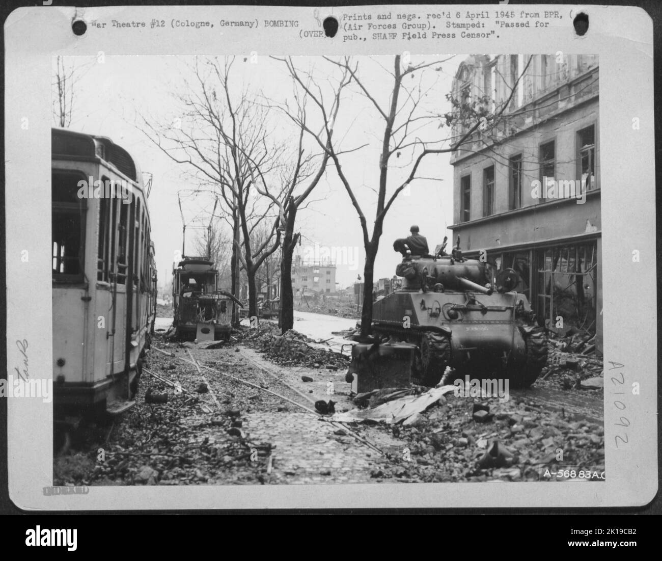 American tanks entering the City of Cologne roll by disabled trolleys ...
