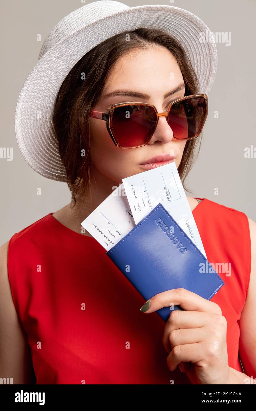 Summer trip. Passport control. Woman in red dress white hat sunglasses ...