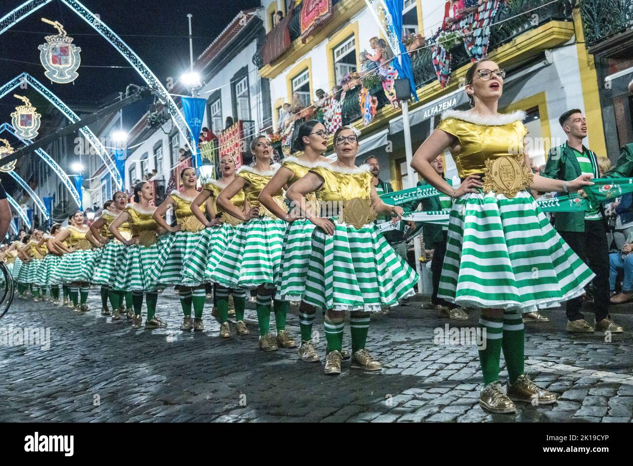 Costumed performers dance down the Rua da Se during a traditional ...