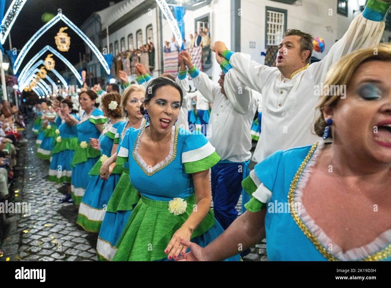Costumed performers dance down the Rua da Se during a traditional ...