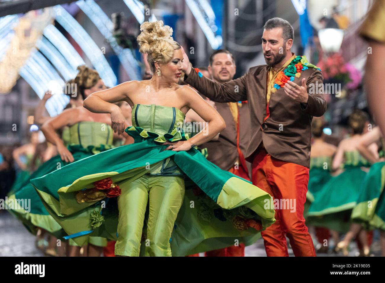 Costumed performers dance down the Rua da Se during a traditional ...