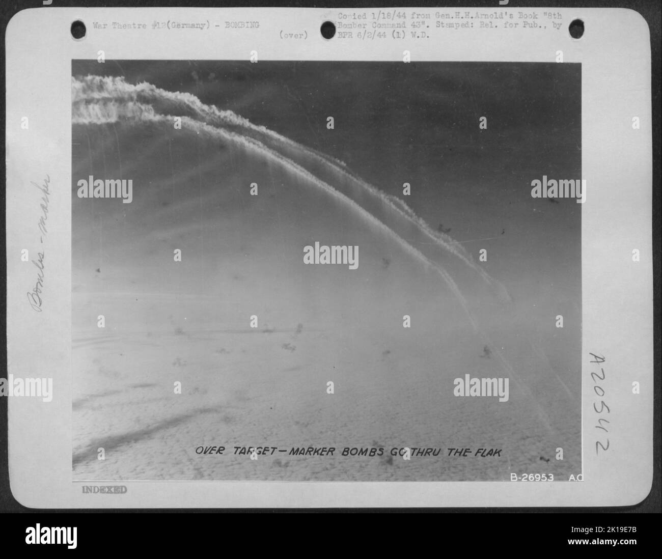 Both the white smoke trails of the "marker" bombs and the flak puffs of ...