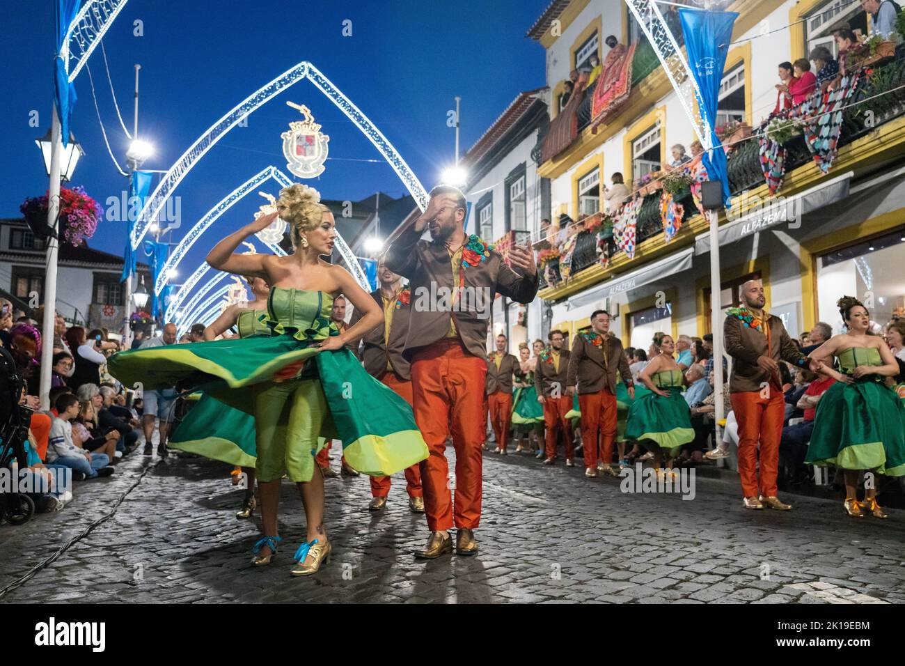 Costumed performers dance down the Rua da Se during a traditional ...