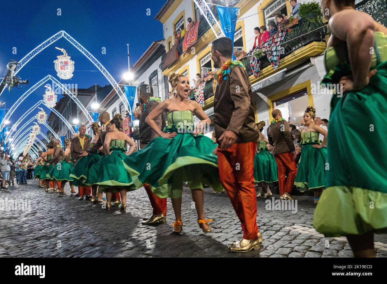 Costumed performers dance down the Rua da Se during a traditional ...