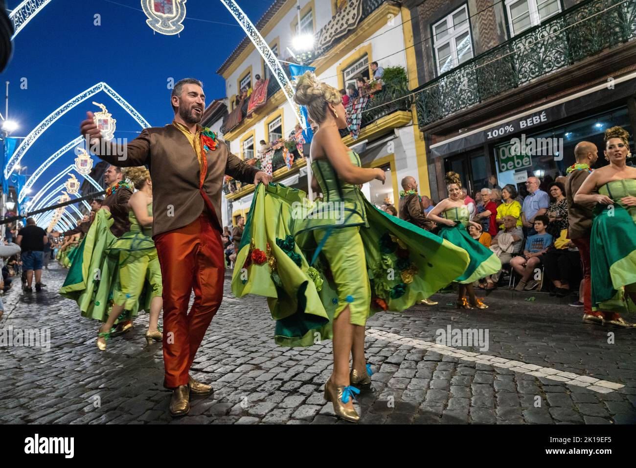 Costumed performers dance down the Rua da Se during a traditional ...