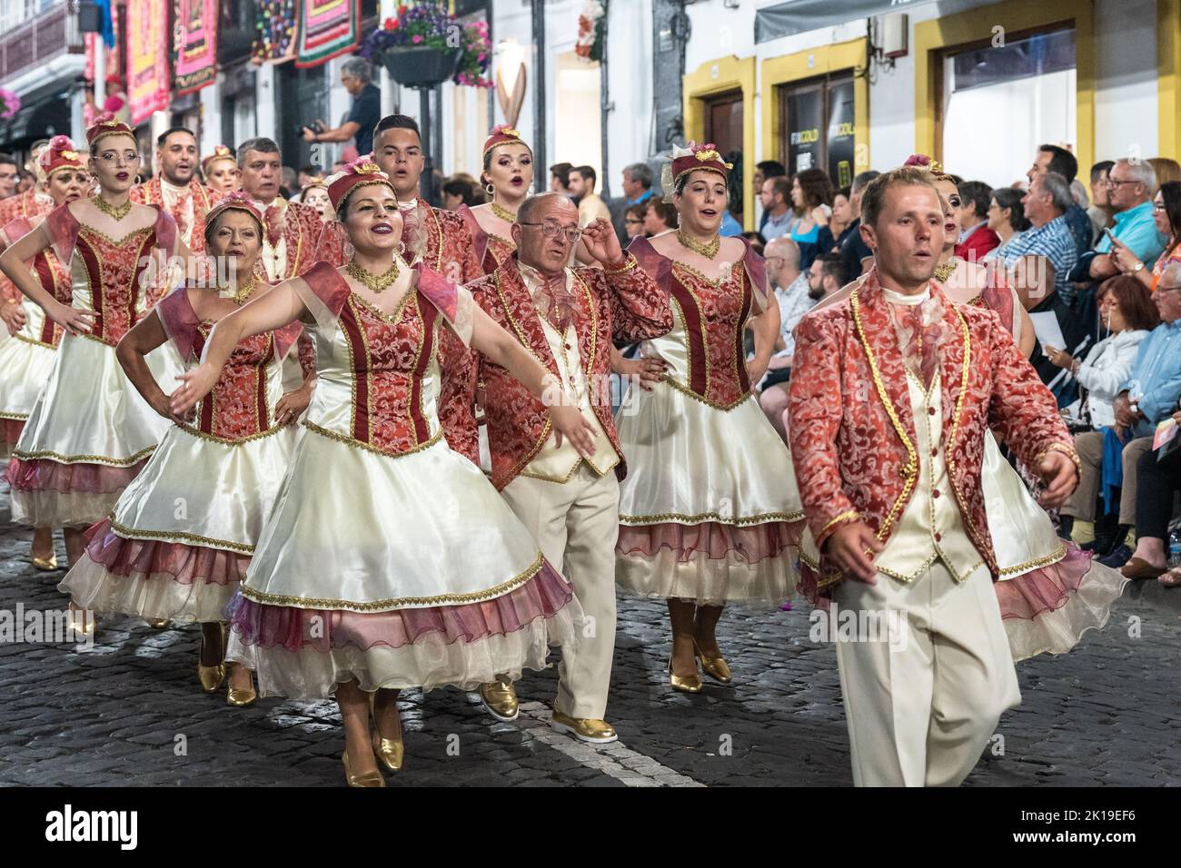 Costumed performers dance down the Rua da Se during a traditional ...