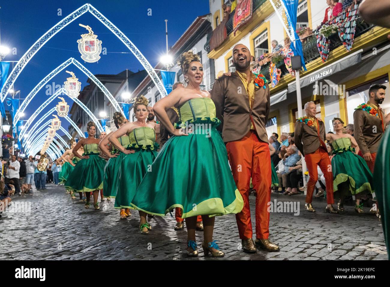 Costumed performers dance down the Rua da Se during a traditional ...
