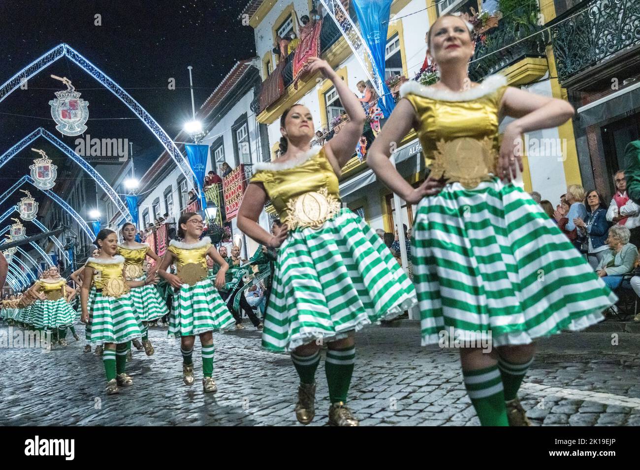 Costumed performers dance down the Rua da Se during a traditional ...