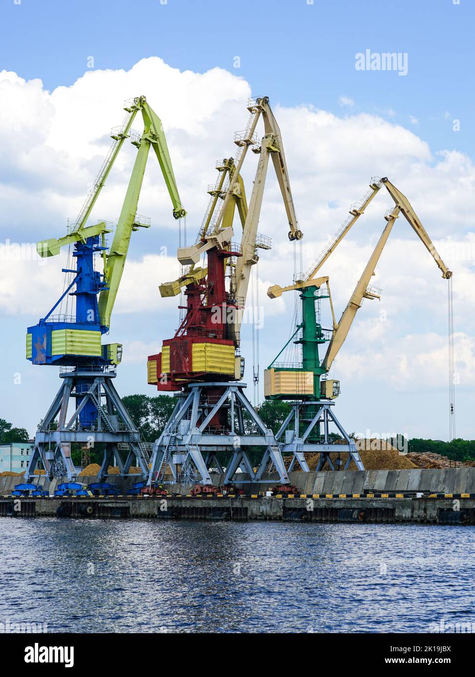 Bulk cargo terminal in port with many shore cranes and piles of coal ...