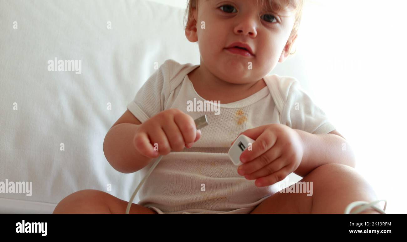 Baby unplugging smartphone charger cable, toddler boy unplugs cellphone ...