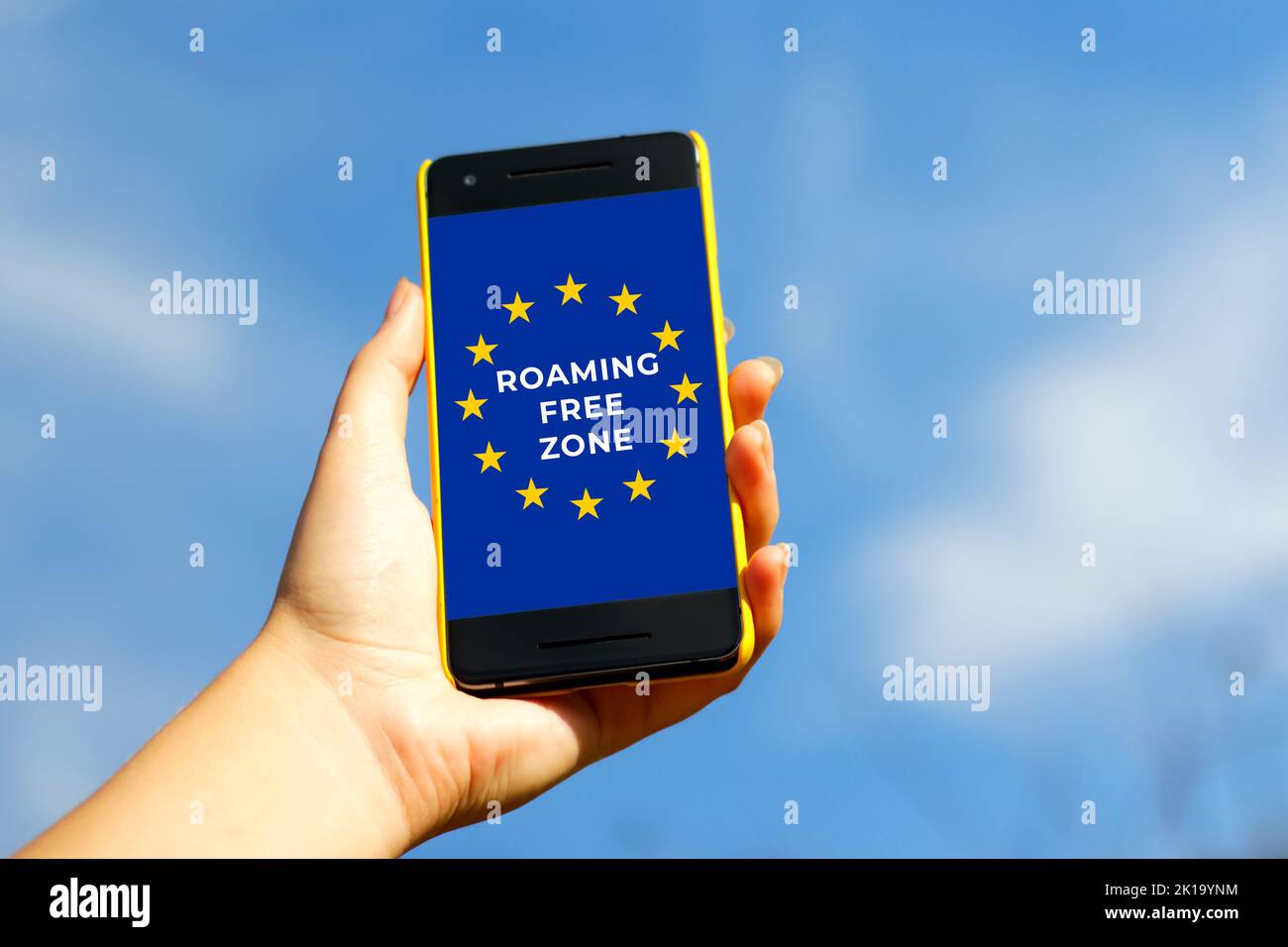 Roaming Free Euro Zone. Woman hand holding black smartphone in yellow ...
