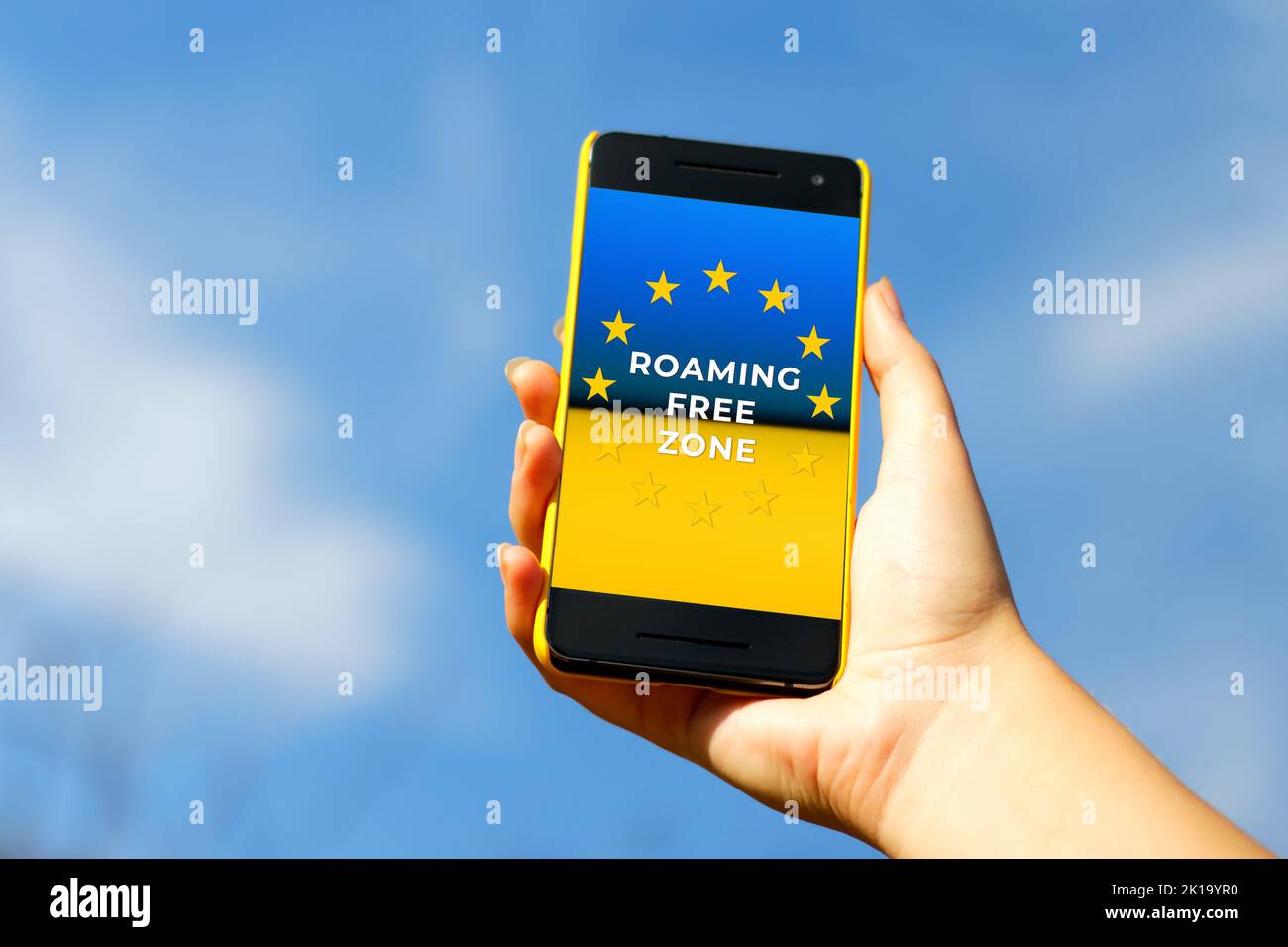 Roaming Free Euro Zone. Woman hand holding black smartphone in yellow ...