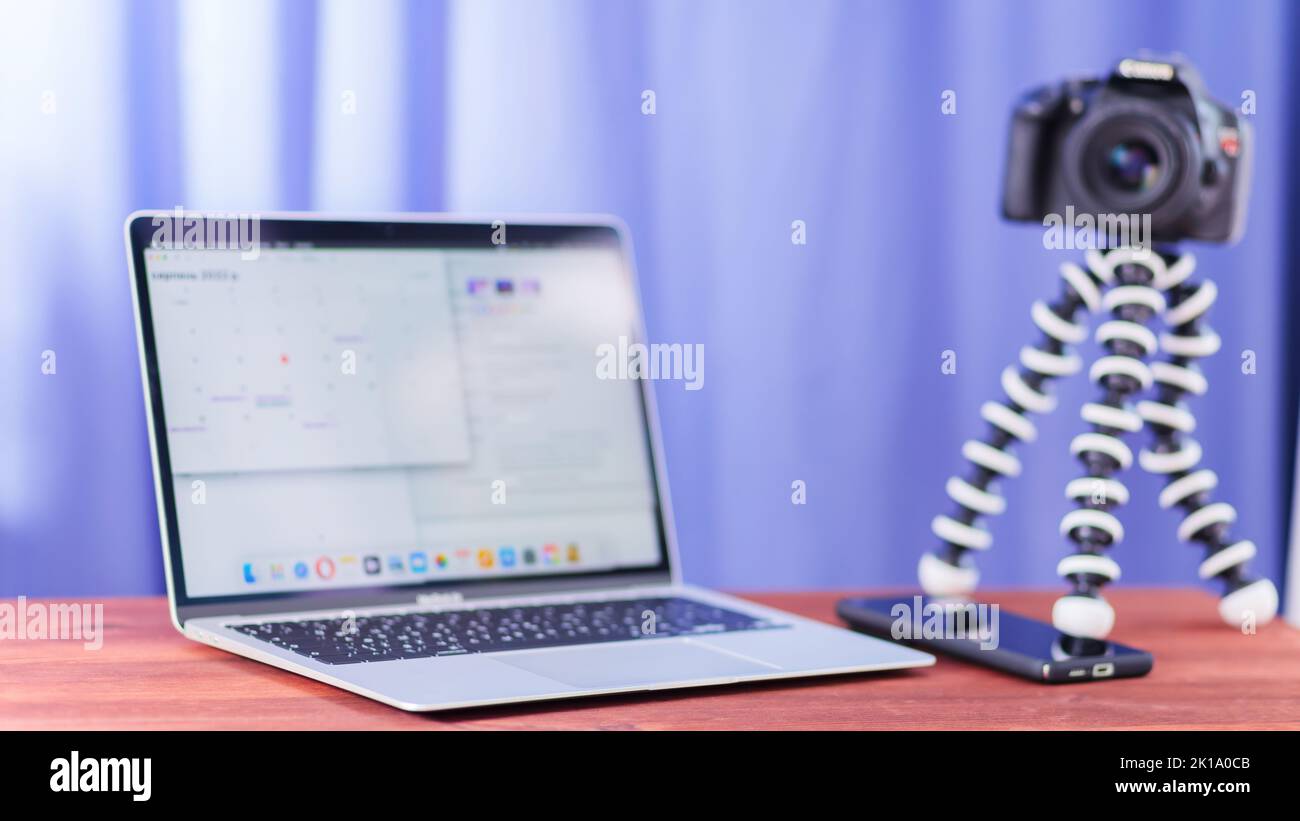 Vlogger workplace. Laptop, smartphone and SLR camera on a wooden table ...