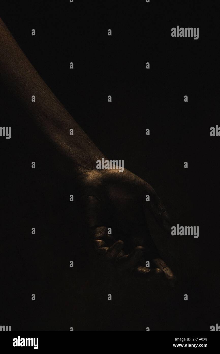 A vertical shot of a human arm in the dark Stock Photo - Alamy