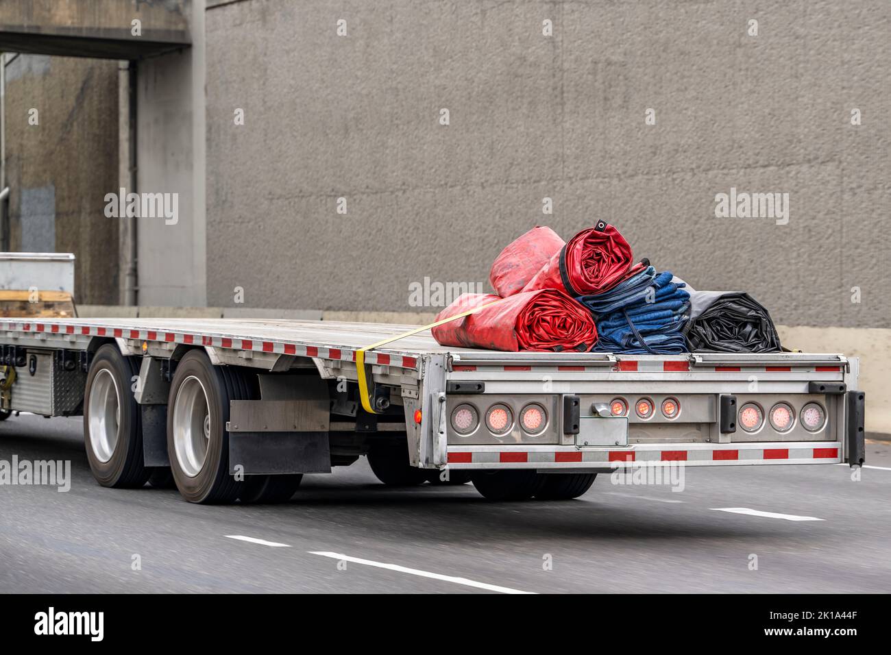 Industrial grade big rig long haul semi truck transporting rolled up ...