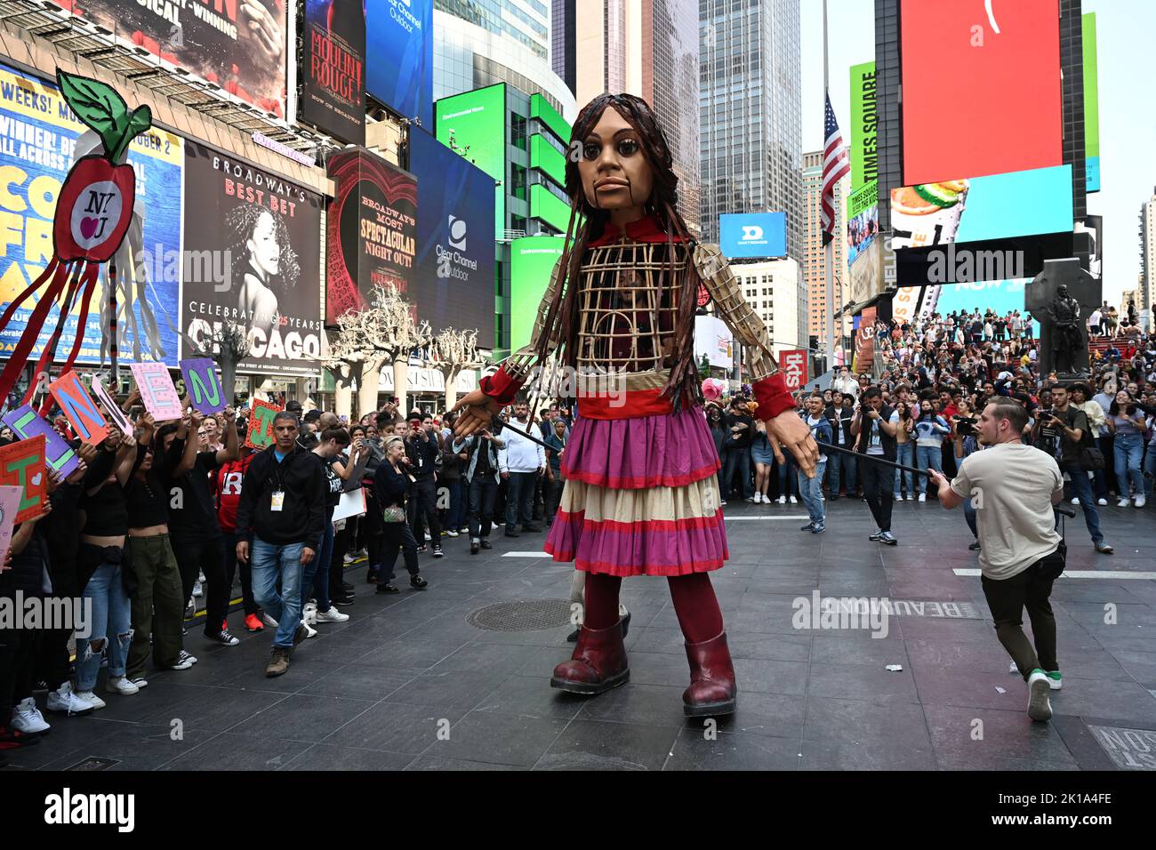 The 12-foot puppet known as "Little Amal" walks through Times Square as ...