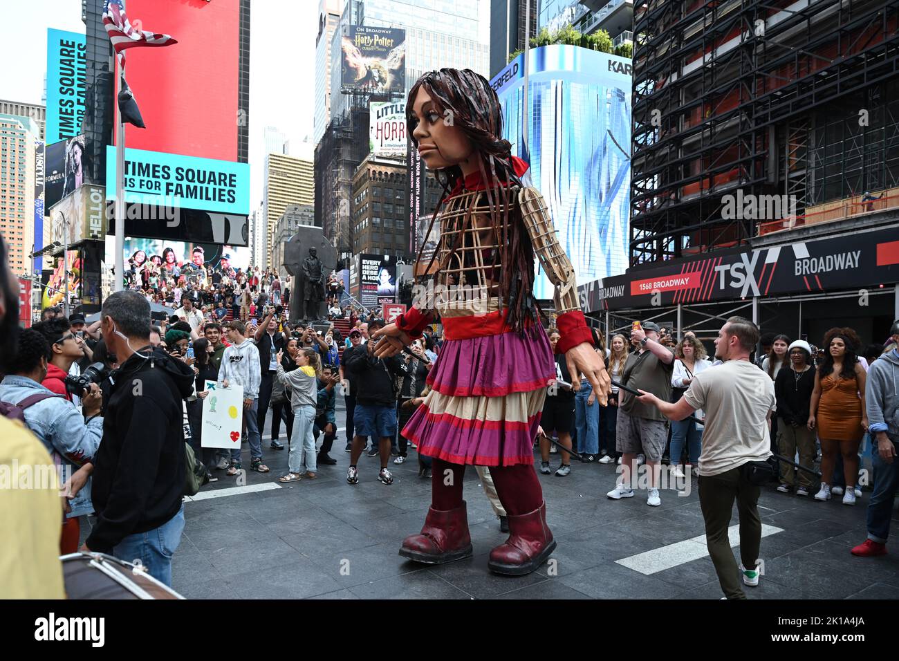 The 12-foot puppet known as "Little Amal" walks through Times Square as ...