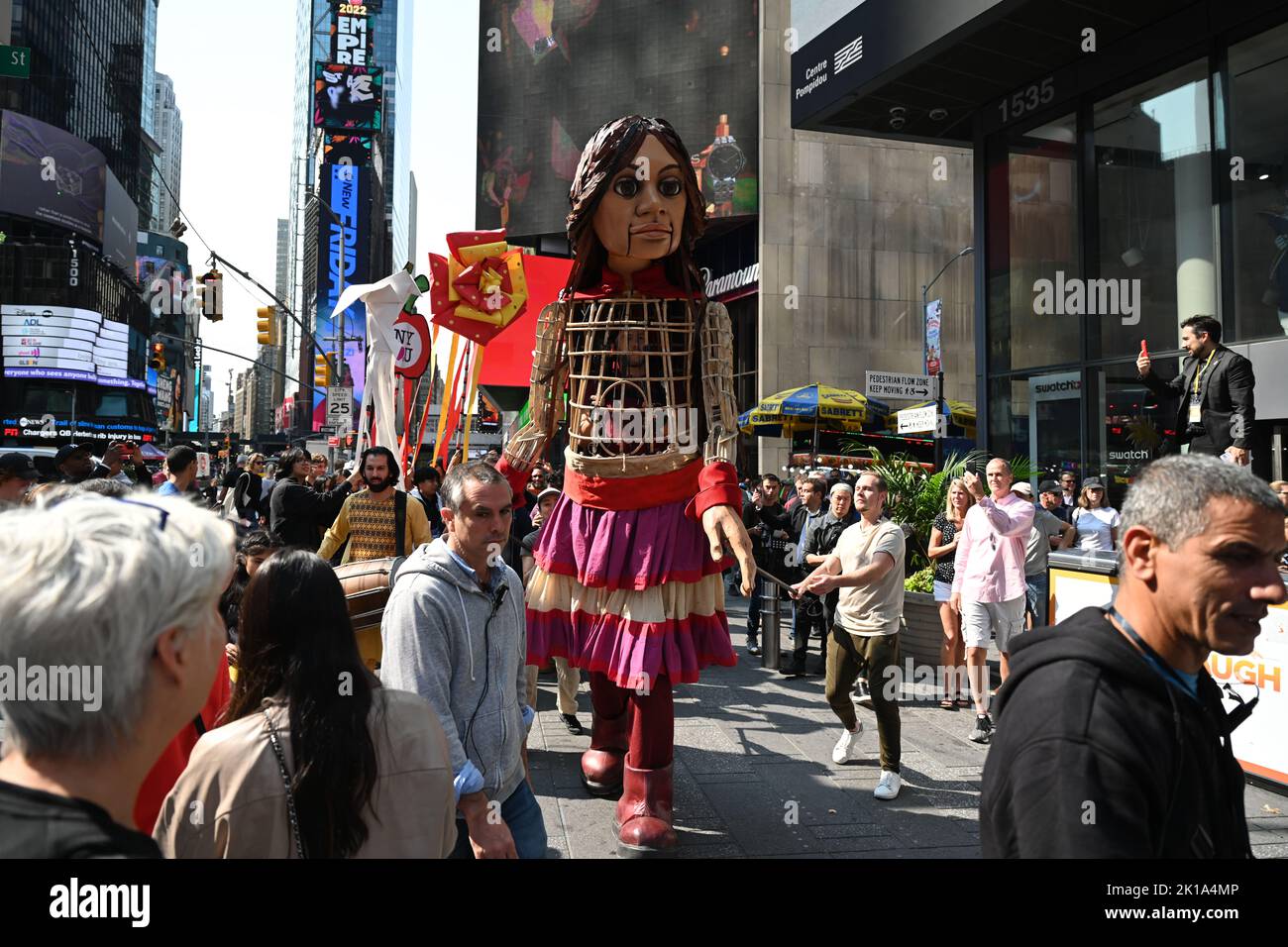 The 12-foot puppet known as "Little Amal" walks through Times Square as ...