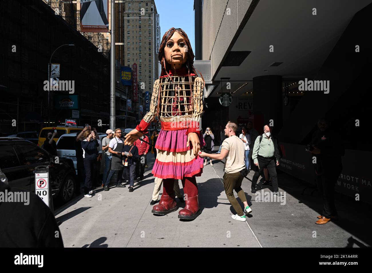 The 12-foot puppet known as "Little Amal" walks through Times Square as ...