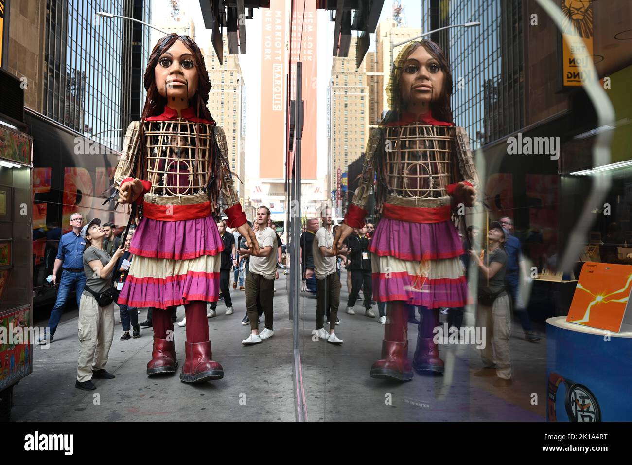 The 12-foot puppet known as "Little Amal" walks through Times Square as ...