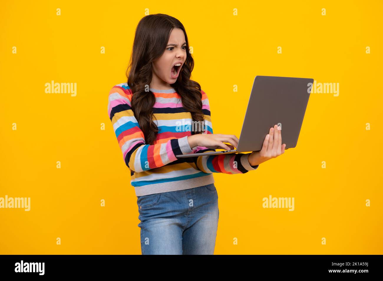 Young girl student hold computer. Funny pupil with laptop isolated on ...