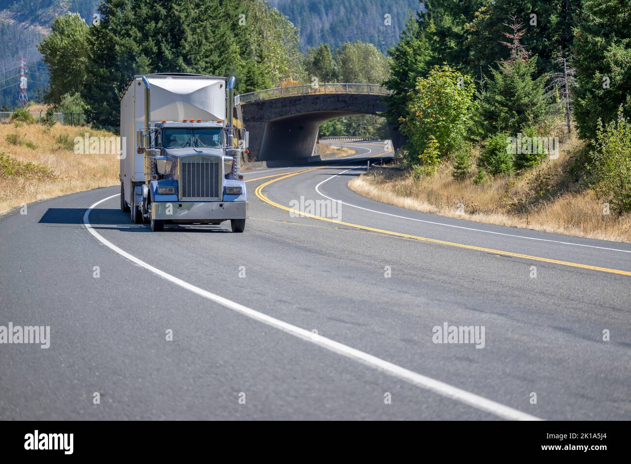Industrial classic big rig blue American semi truck transporting ...