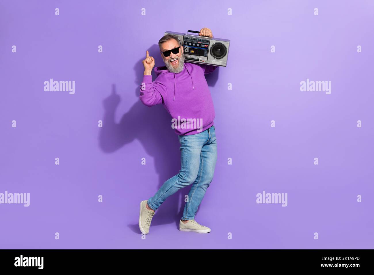 Photo of old carefree funny positive man purple hoodie hold boombox ...