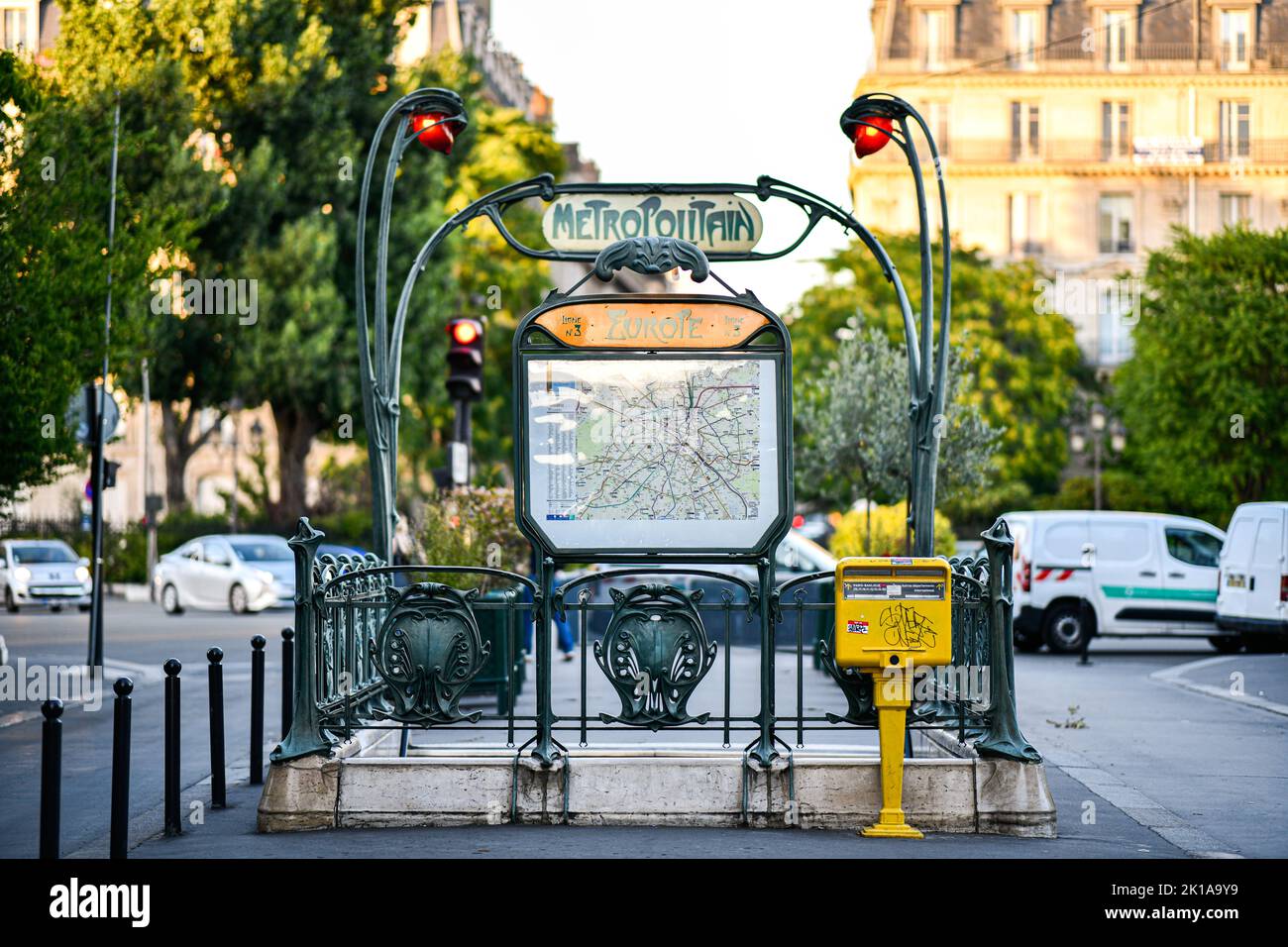 Sign with the subway logo (yellow symbol) in front of a parisian metro ...
