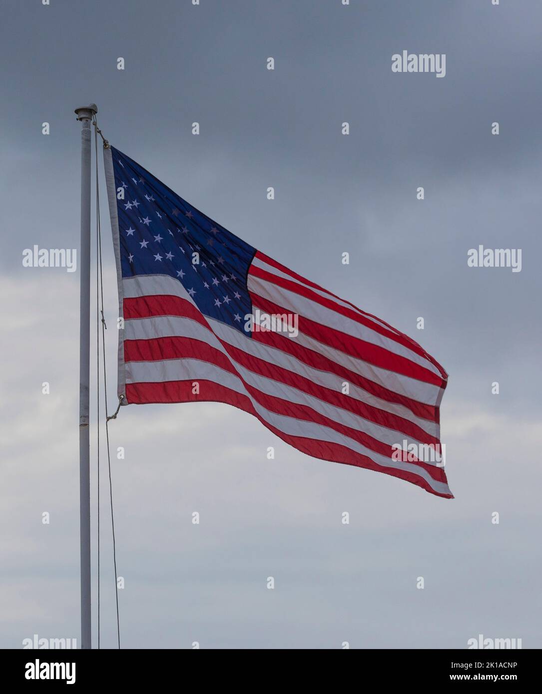 American flag blowing in the wind with clouds behind Stock Photo - Alamy