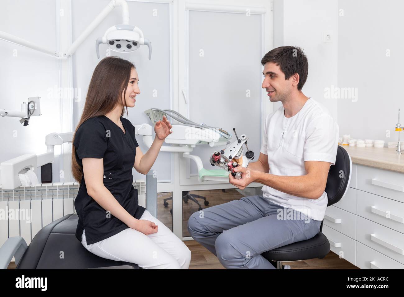 Dentist holding dental articulator with dental gypsum prosthesis model ...