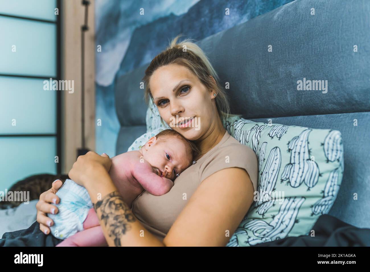 Young caucasian blond mother in casual clothing with her first-born ...