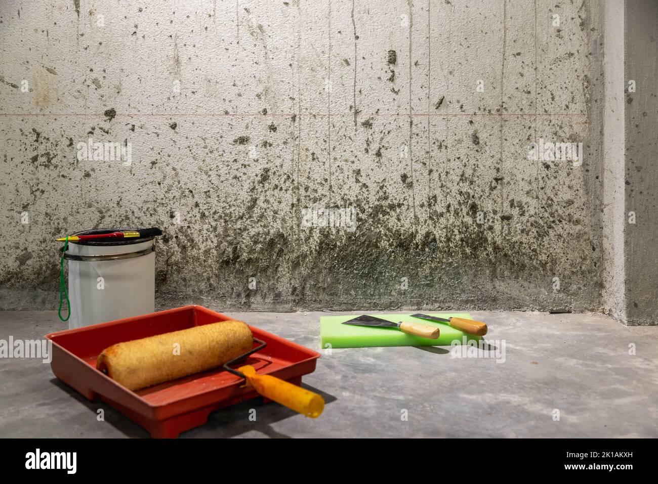 Renovation home , Painter scraping concrete debris on wall from pour ...