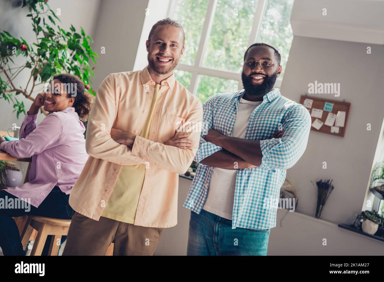 Photo of handsome confident businesspeople smiling arms folded indoors ...