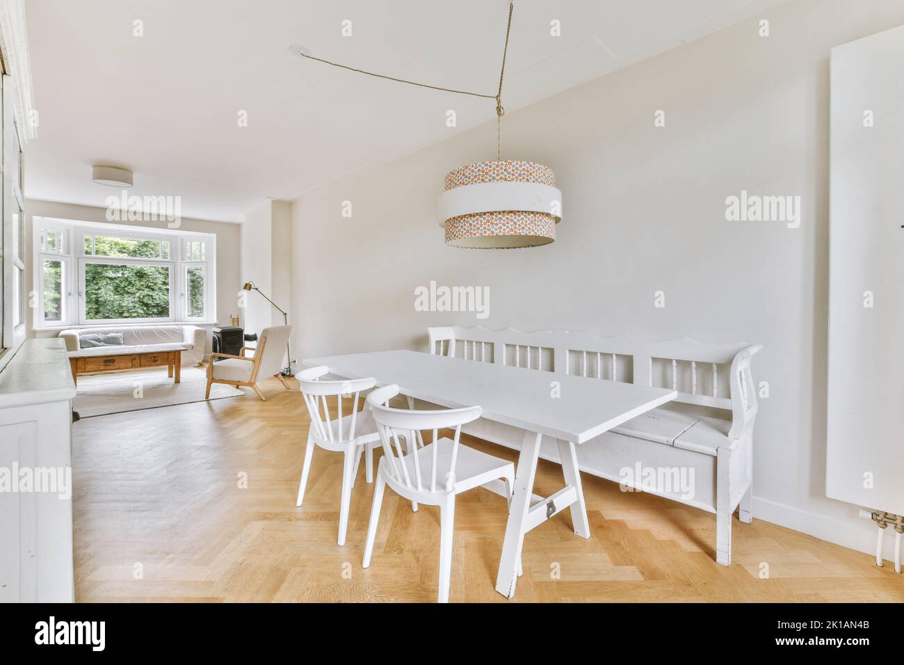 Shabby wooden table with chairs and vase located near comfortable couch ...